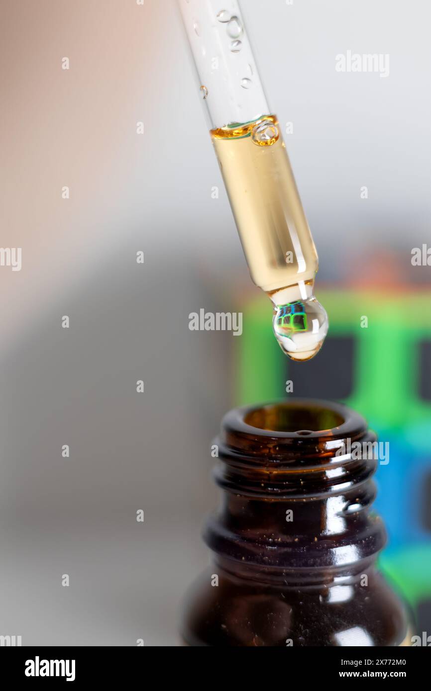Close-Up Of Dropper With Liquid Over Brown Bottle. A close-up image ...