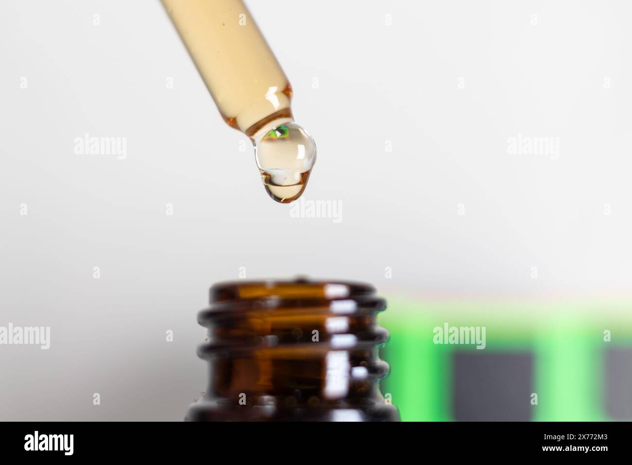 Close-Up Of Dropper With Liquid Over Brown Bottle. A close-up image ...