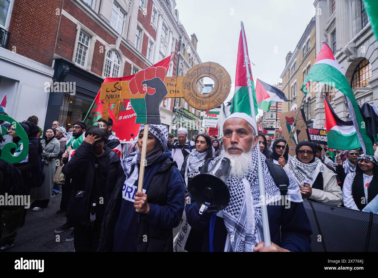 London, UK. 18 May, 2024. Protesters carry a key symbol of a home lost ...