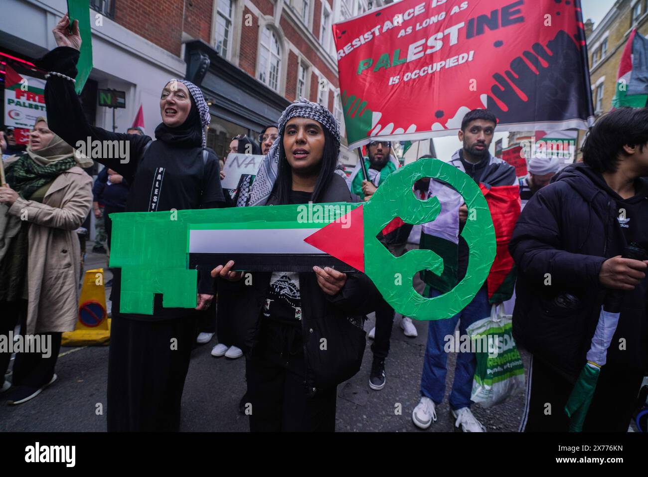 London, UK. 18 May, 2024. Protesters carry a key symbol of a home lost ...