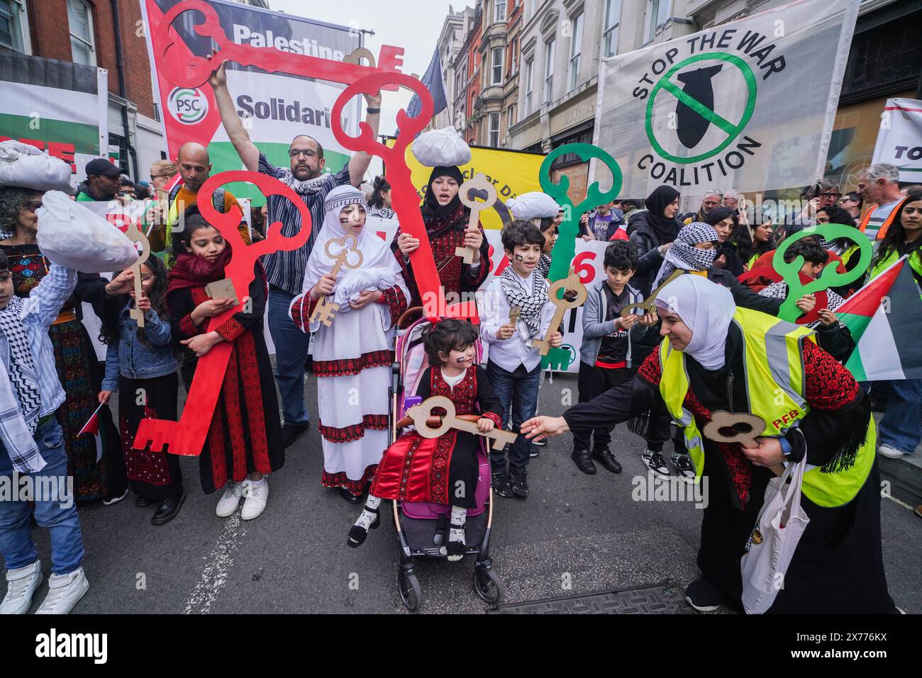 London, UK. 18 May, 2024. Protesters carry a key symbol of a home lost ...