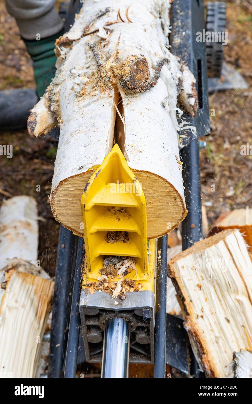 The high-speed process of splitting a log with an electric wood ...
