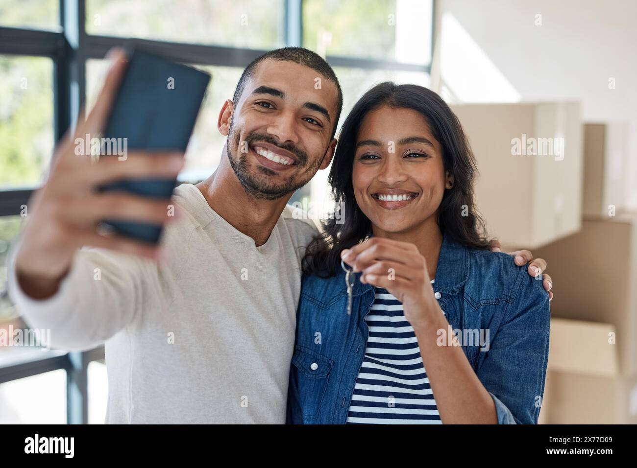 Selfie, house key and couple moving to new home together with cardboard ...