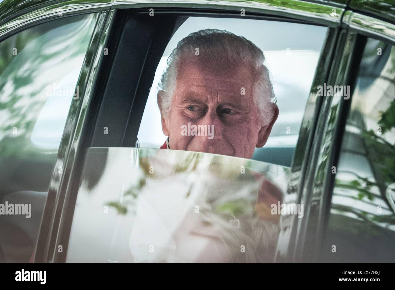 King Charles III peeks through the window whilst driven by car, London ...