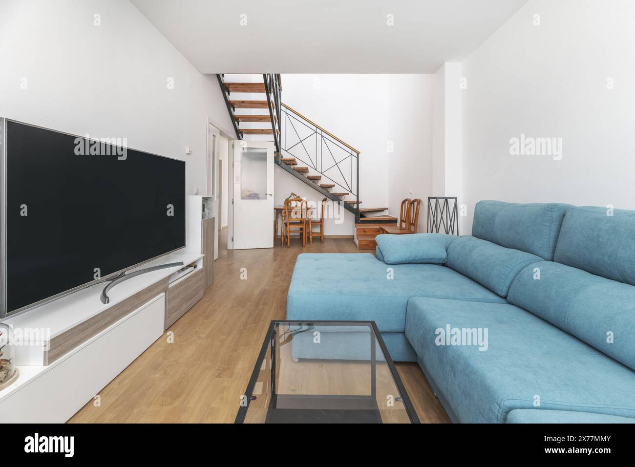 Living room with a large sofa upholstered in blue fabric, some ...