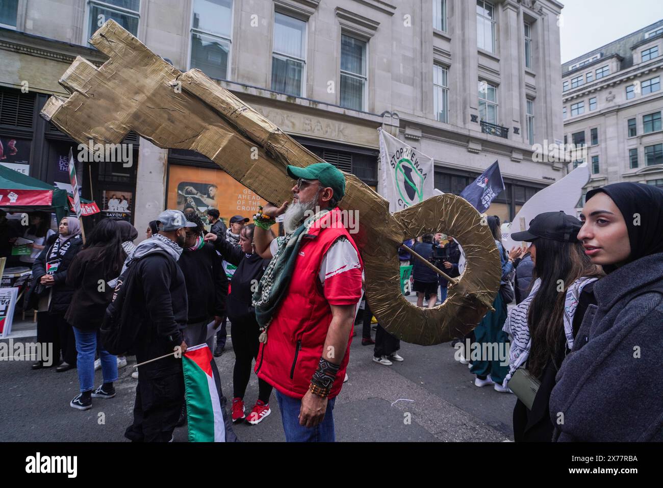 London, UK. 18 May, 2024. A Pro Palestinian supporter carries a large ...