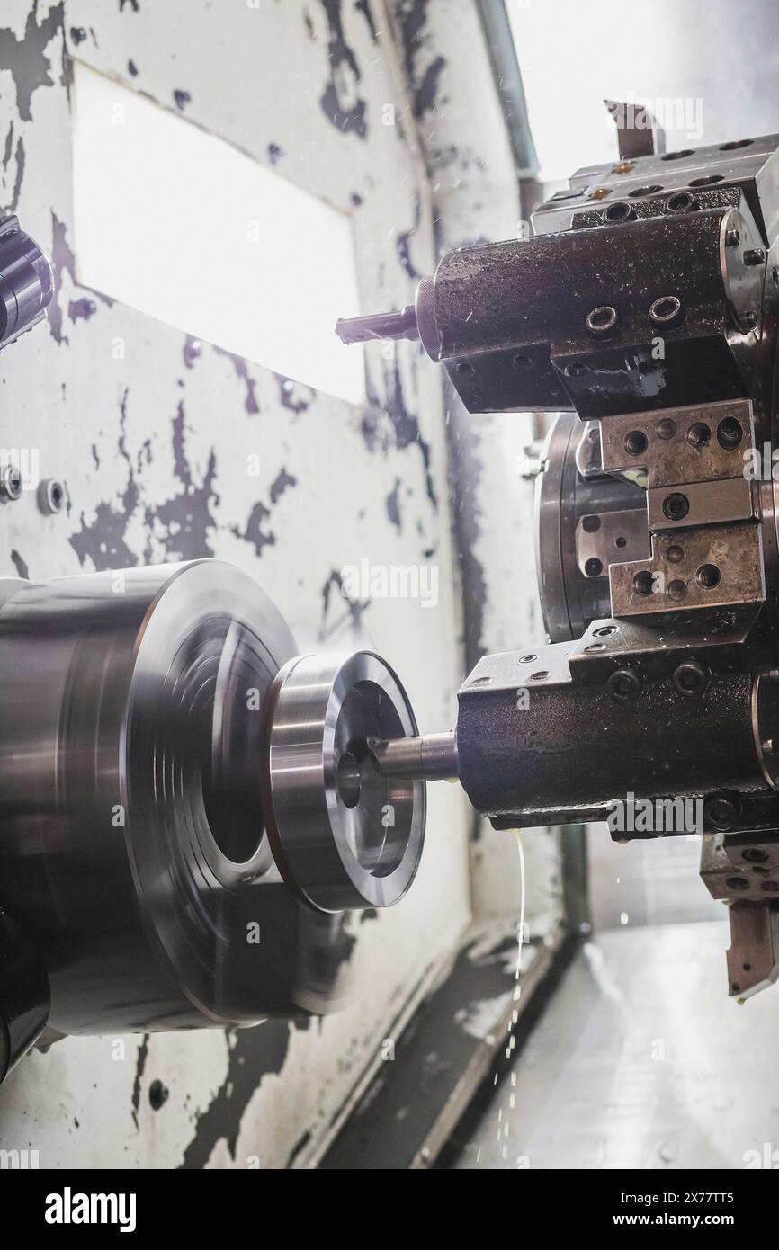 A milling cutter in a CNC machine cuts a metal workpiece that rotates ...