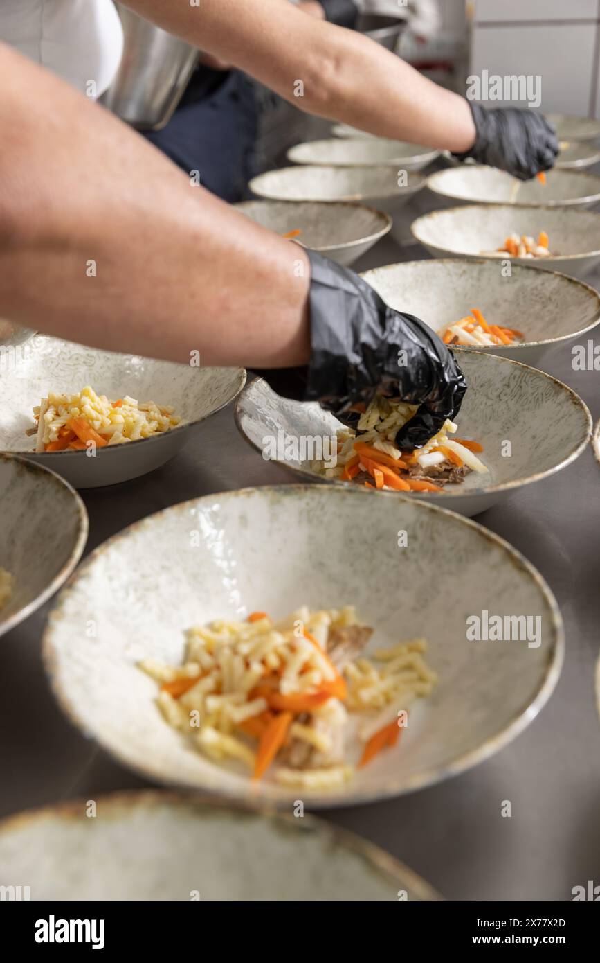 Professional chef plating food in commercial kitchen Stock Photo - Alamy