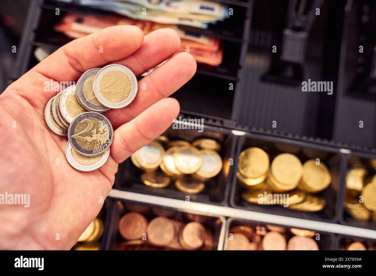 Augsburg, Bavaria, Germany - 18 May 2024: Hand holding two euro change ...