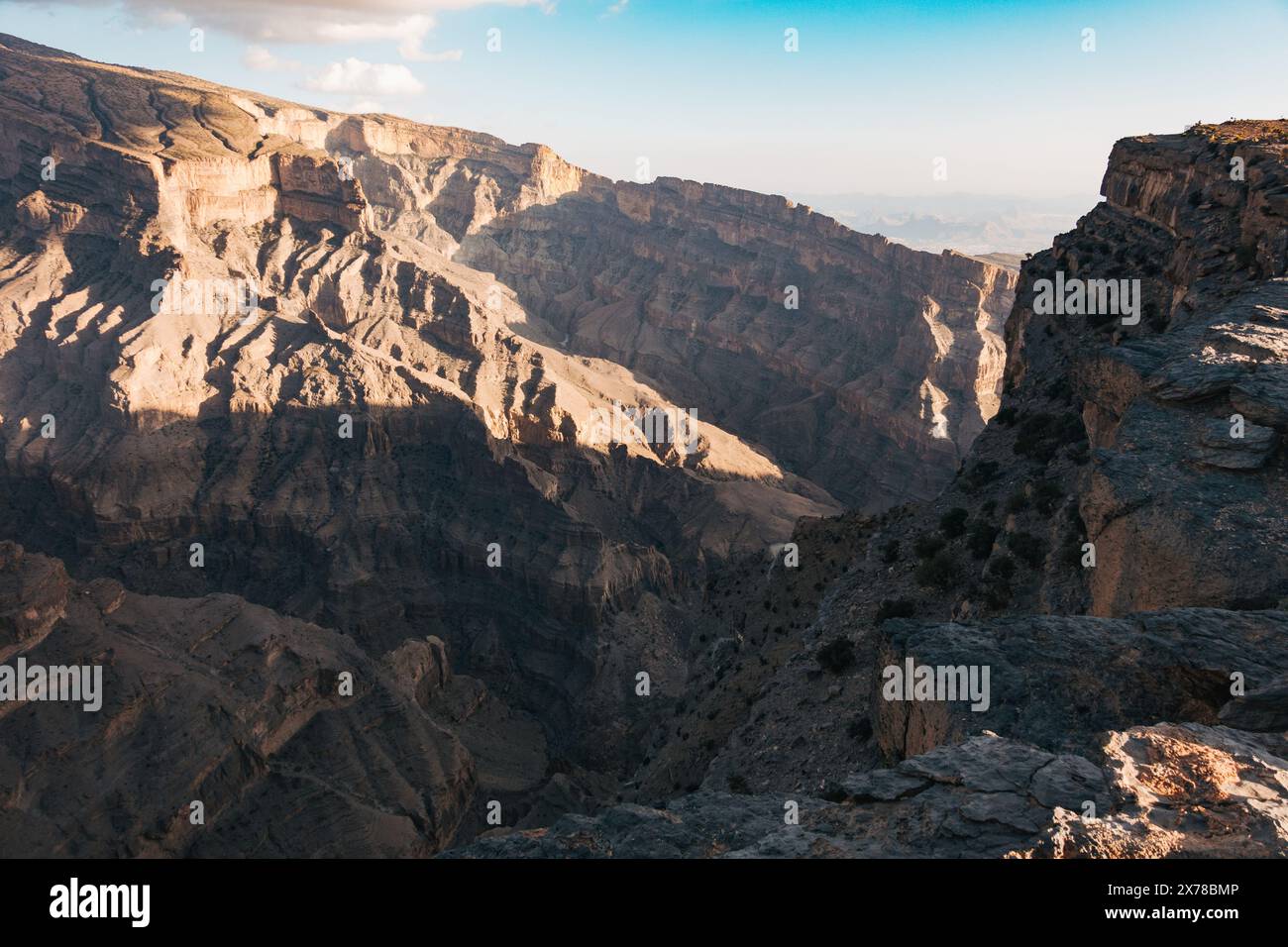 Dramatic cliffs and shadows fall across the canyon walls of Jebel Shams ...