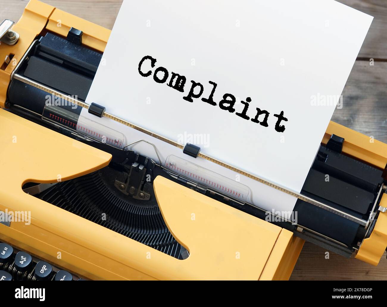 A yellow typewriter displaying the word complaint on paper Stock Photo ...