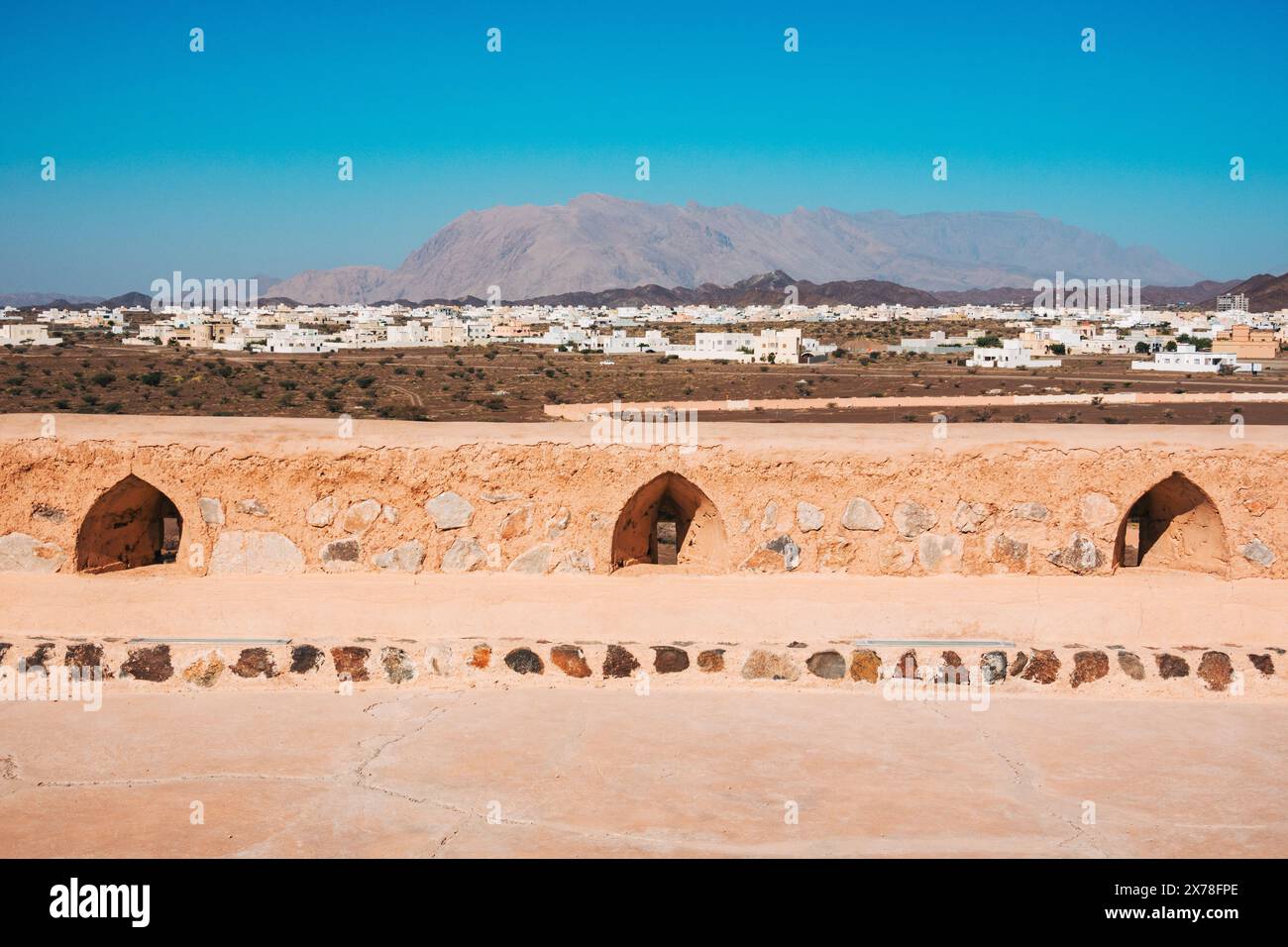 a small wall with arches on the roof of Jabreen Castle, Oman. Built in ...