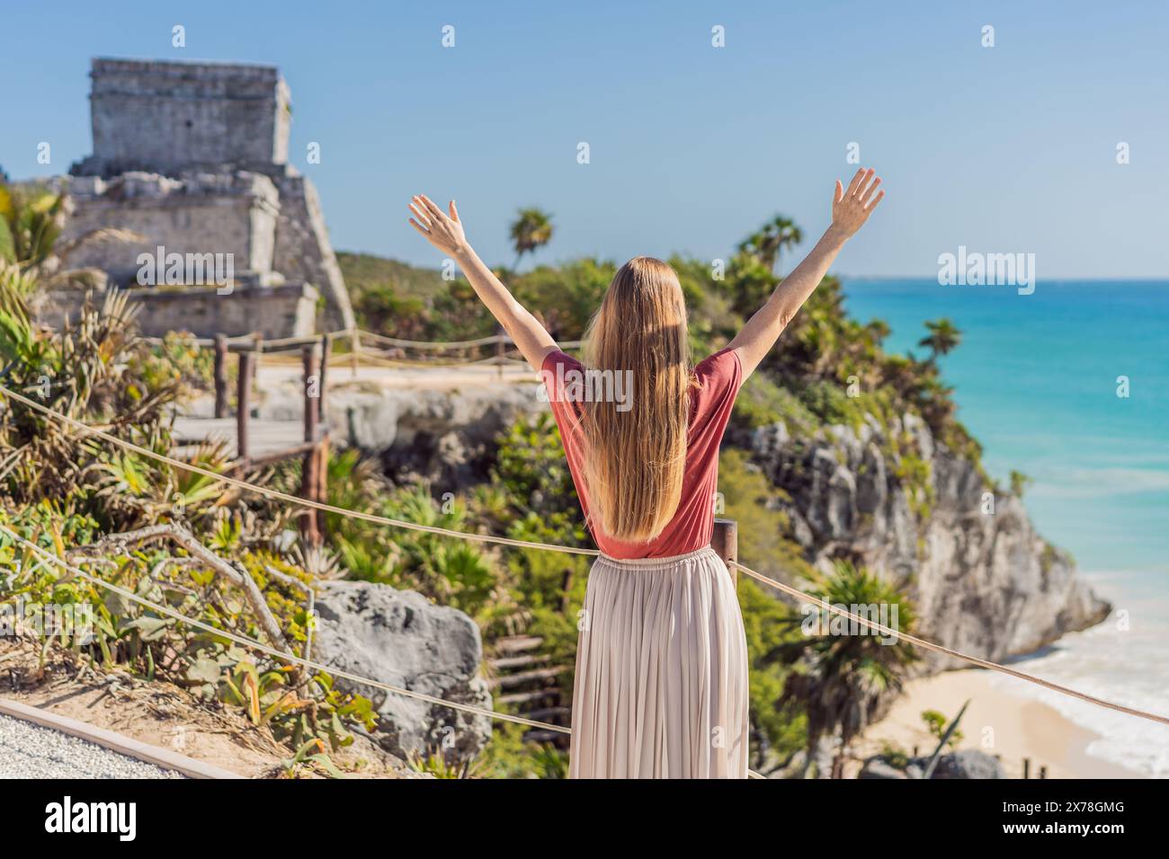 Woman tourist enjoying the view Pre-Columbian Mayan walled city of ...