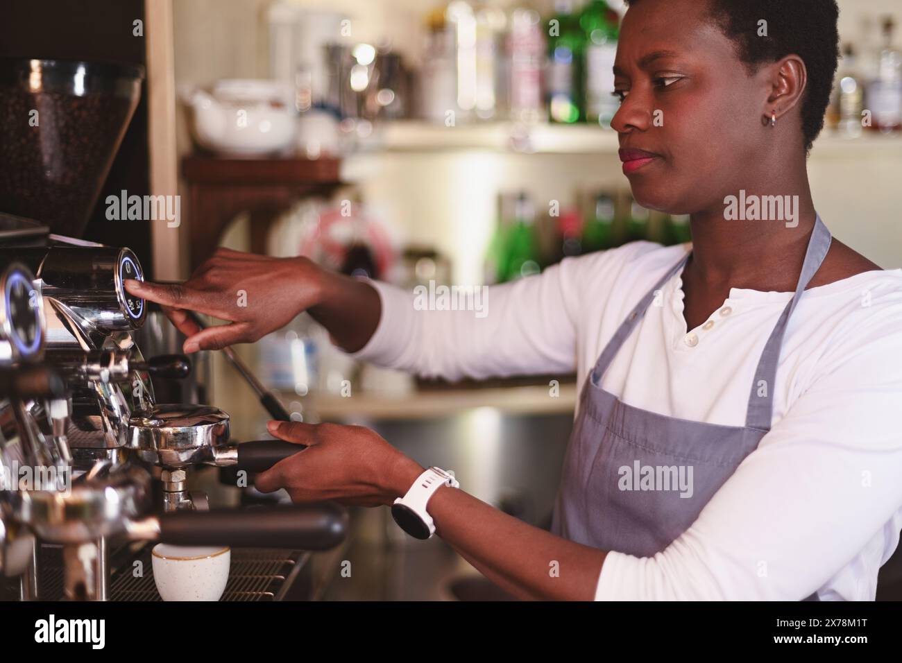 Focused african american barista expertly operates an espresso machine ...