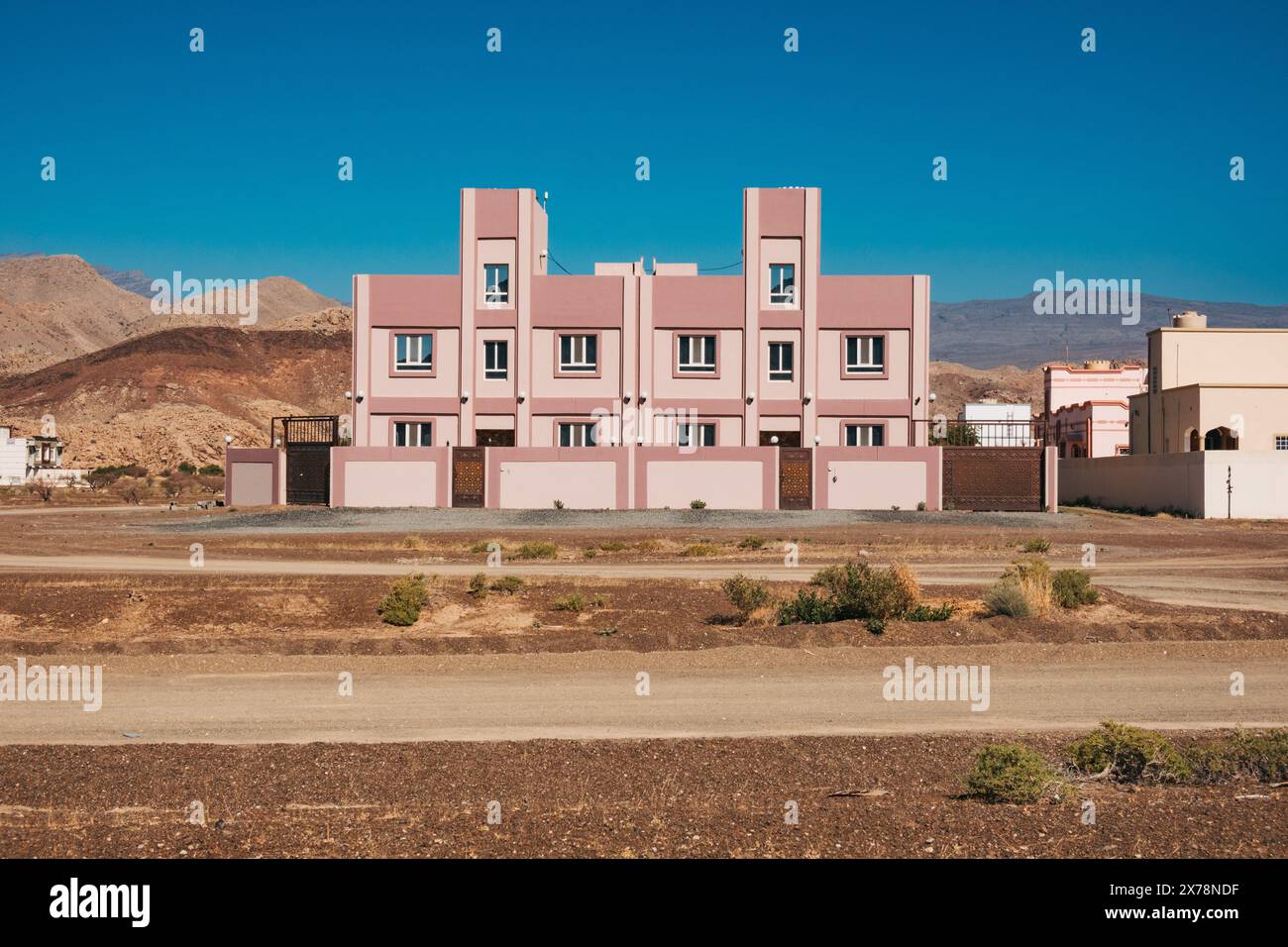 a pink and rectangular regional modernist style home in rural Oman ...