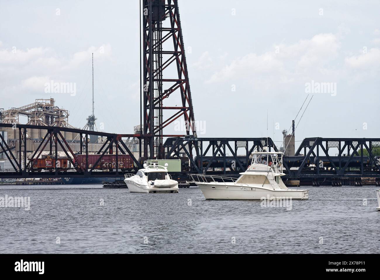 2 boats waiting for bridge to open, train crossing water on bridge ...