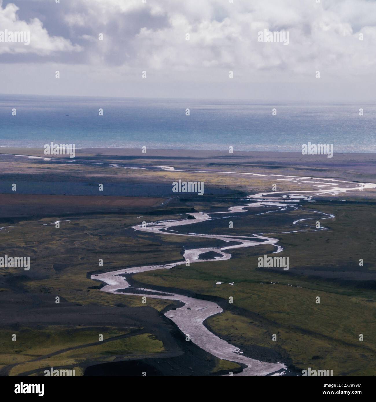 Aerial view of winding river through green valleys and mountains in ...