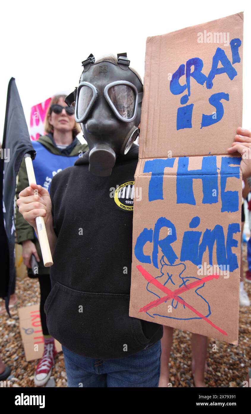 Brighton, England, UK. 18th May, 2024. A young protester wears a gas ...