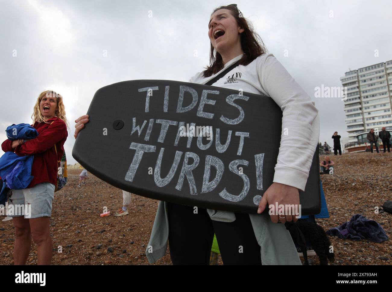Brighton, England, UK. 18th May, 2024. A protester carries a body board ...