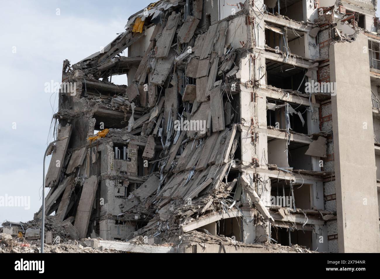 Image of a heavily damaged building with collapsed walls and debris ...