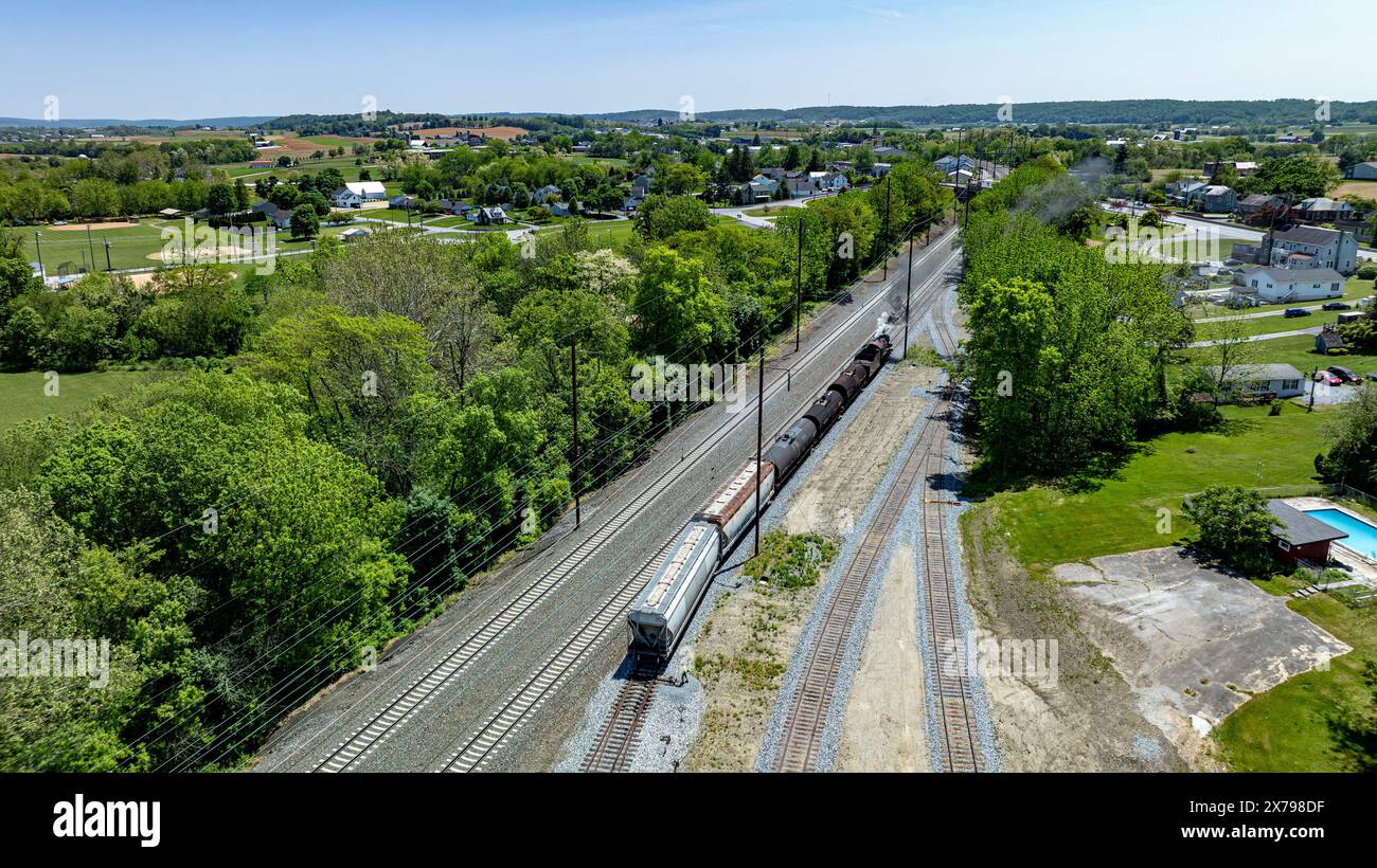 Aerial of a steam engine moving freight in yard to multiple rail tracks ...
