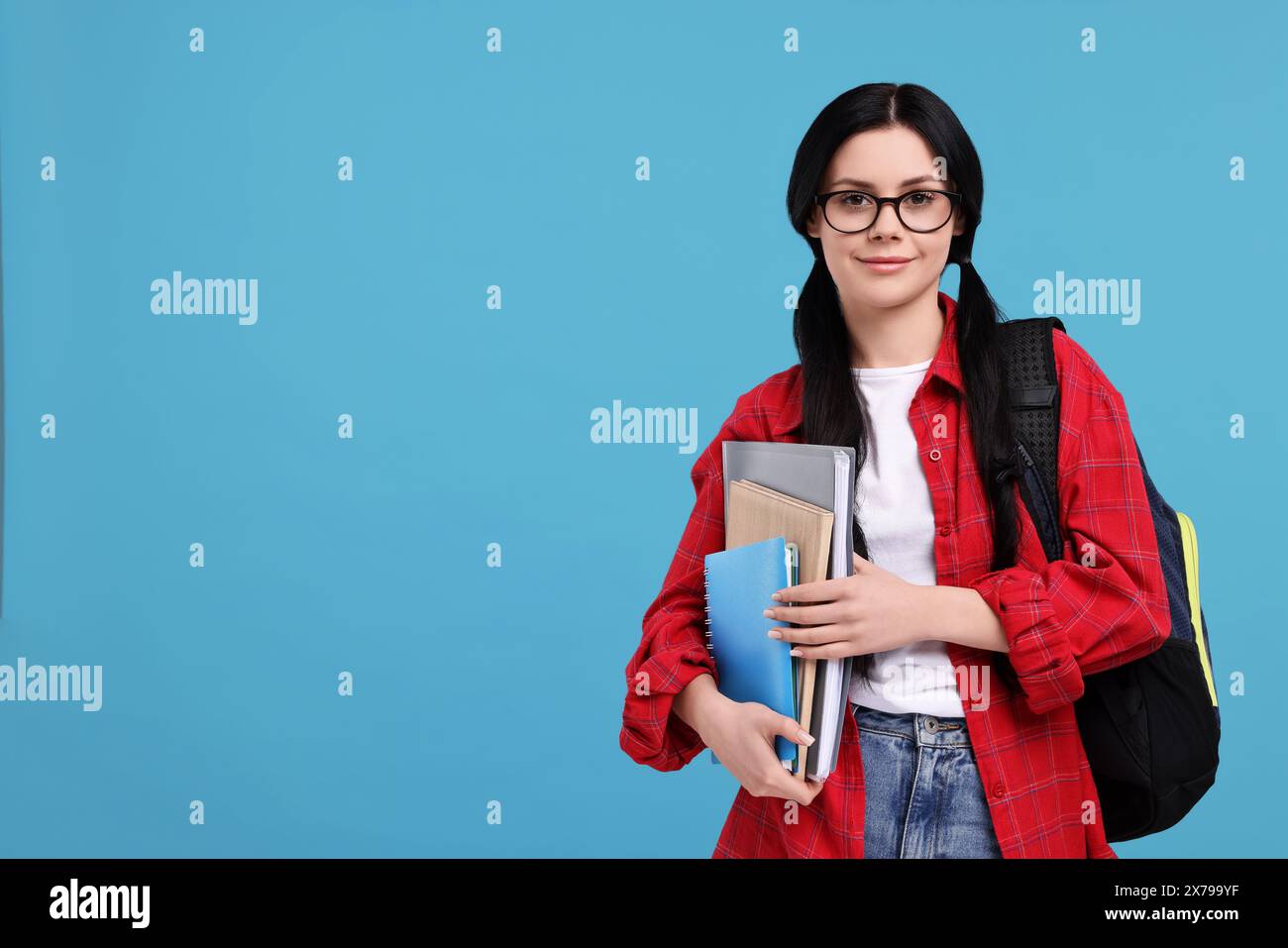 Student with notebooks, folder and backpack on light blue background ...