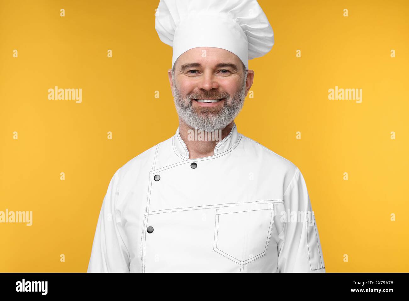 Happy chef in uniform on orange background Stock Photo - Alamy