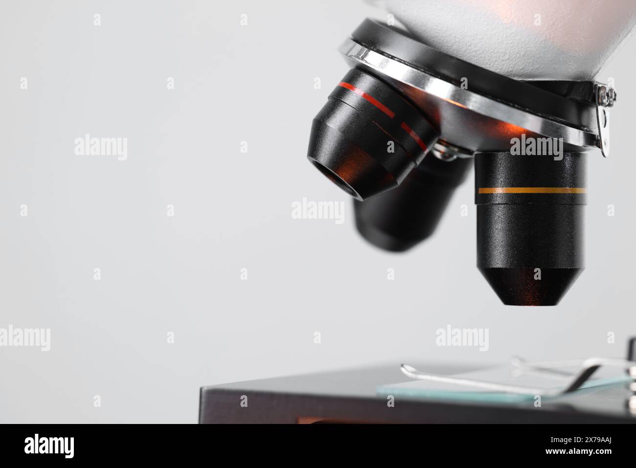 Modern microscope on light background, closeup view. Space for text ...