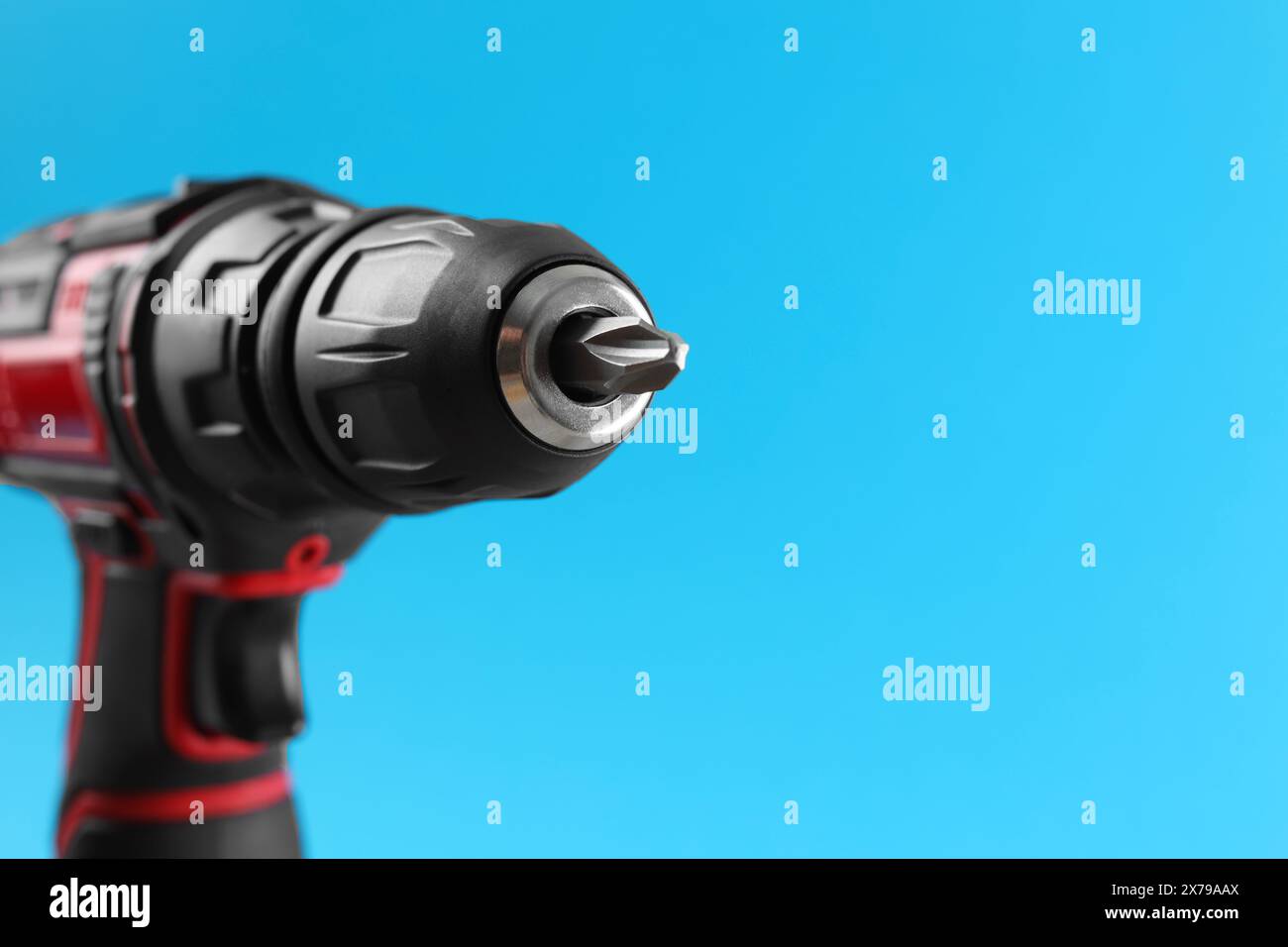 Modern electric screwdriver on light blue background, closeup. Space ...