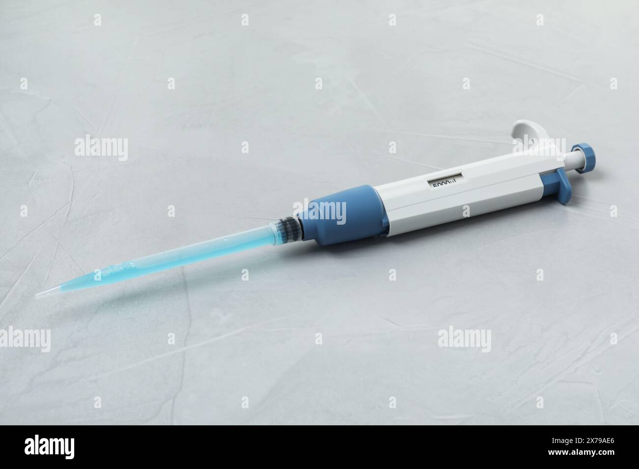 Laboratory analysis. Micropipette with liquid on grey table Stock Photo ...