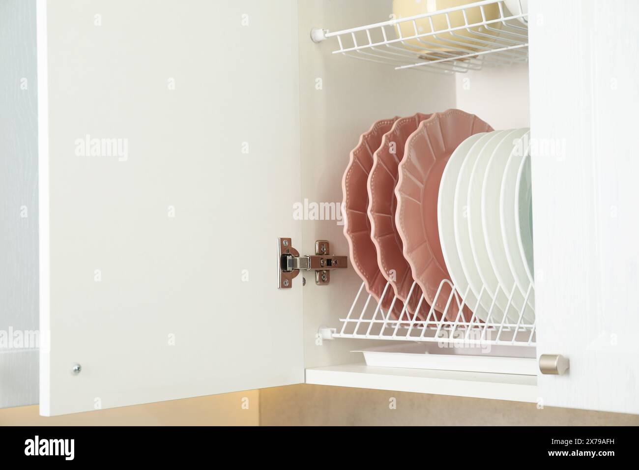 Clean plates on shelf in cabinet indoors Stock Photo - Alamy