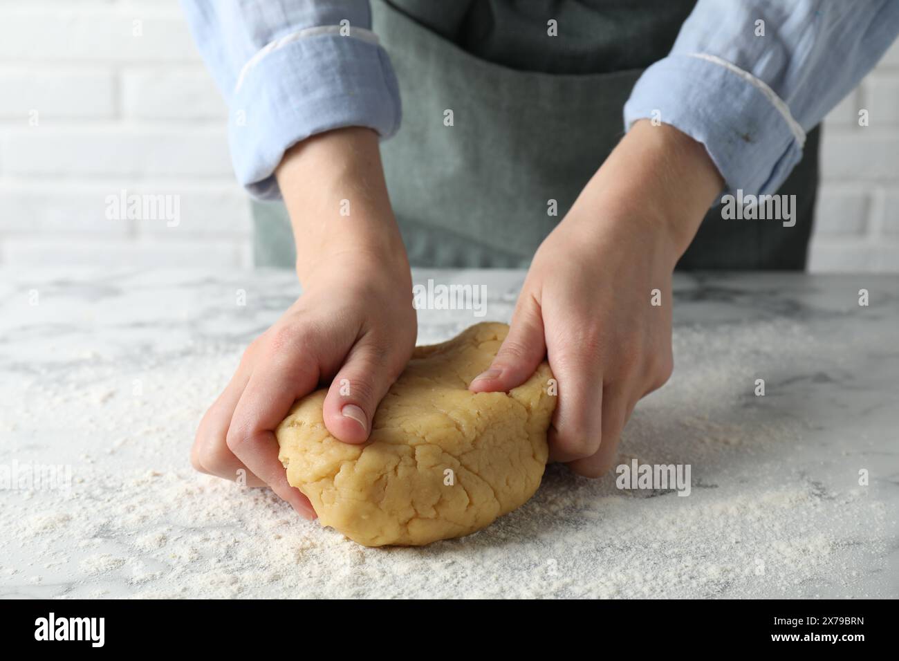 Making shortcrust pastry. Woman kneading raw dough at white marble ...