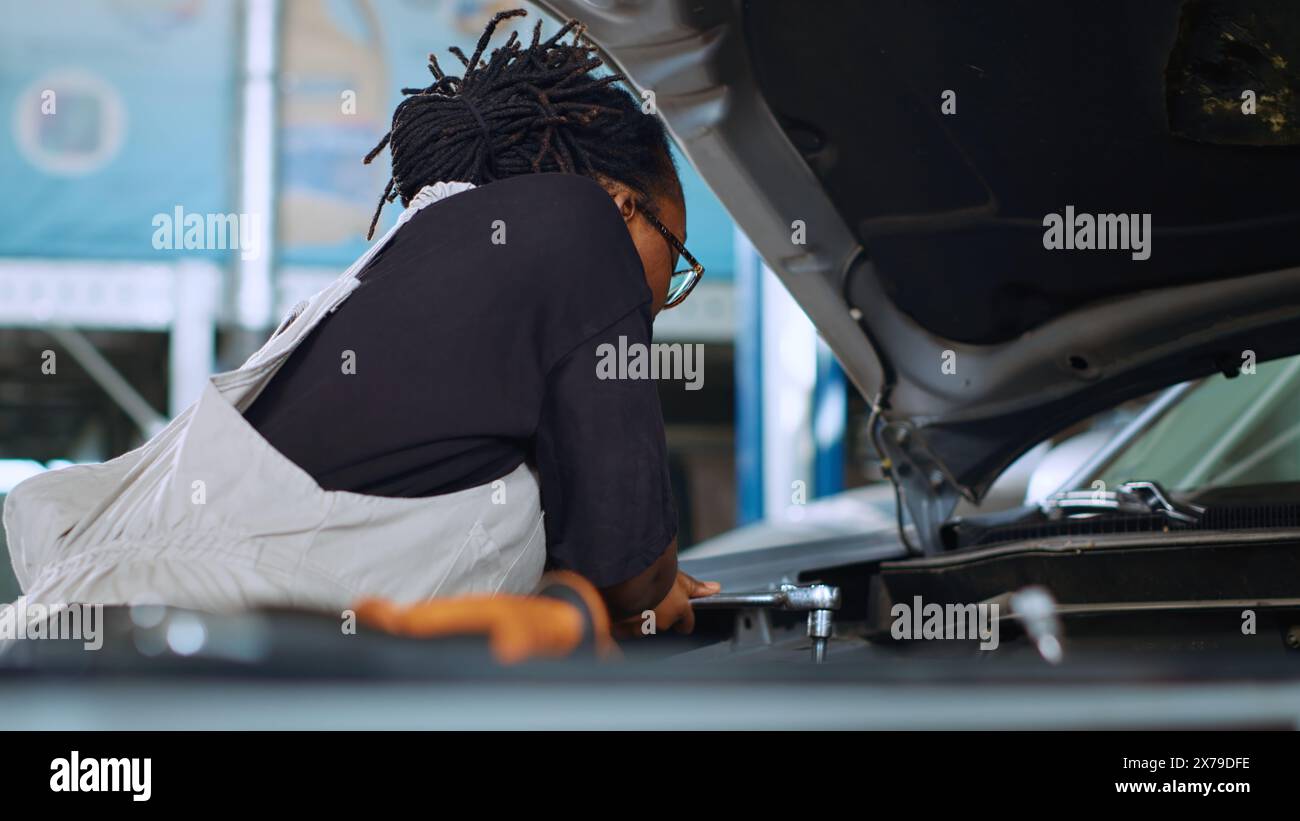 Experienced mechanic in garage using torque wrench to tighten nuts ...