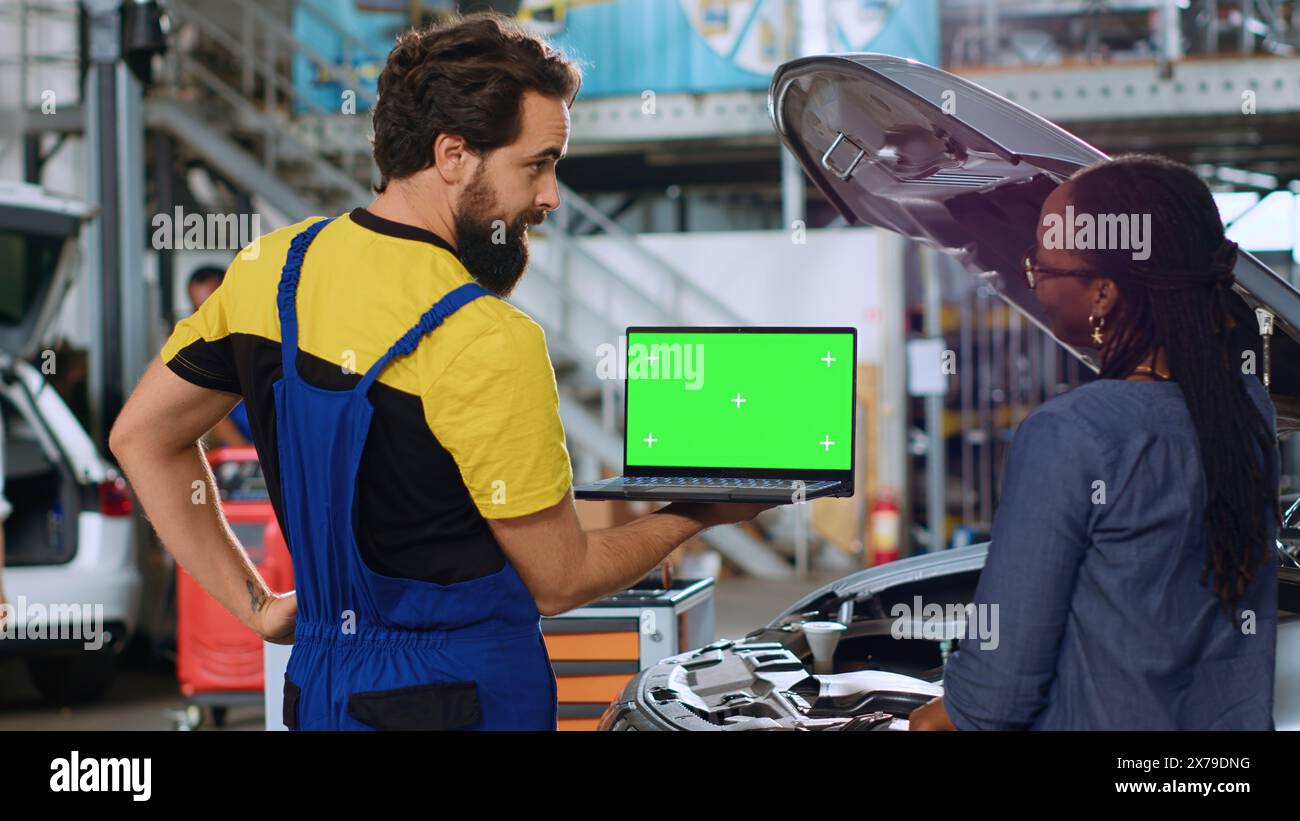 Trained serviceman using green screen laptop in car service to show ...