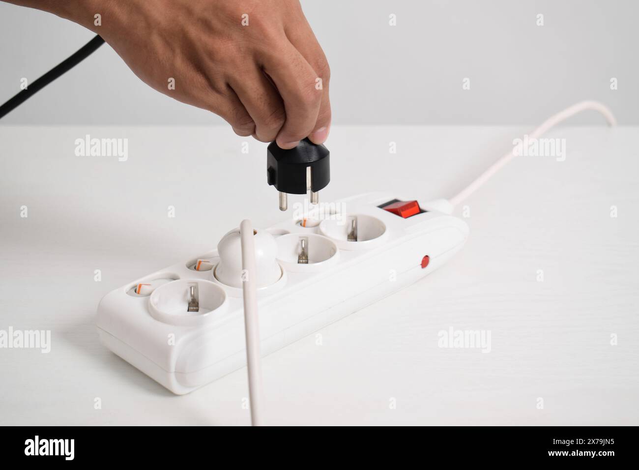 Hand holding electric plug, Multiple socket with connected plugs ... Hand holding electric plug, Multiple socket with connected plugs ...