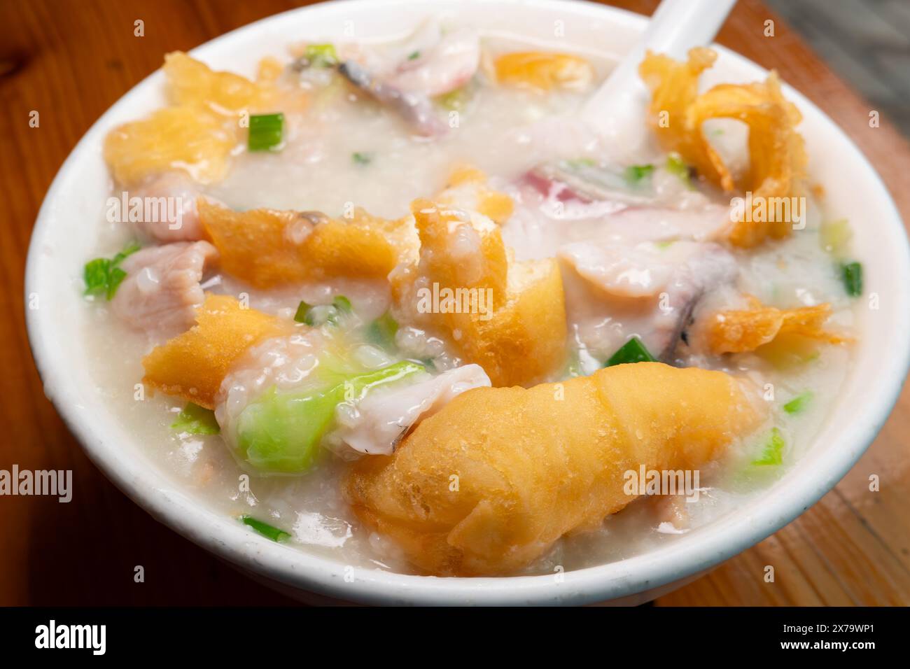 angle view fish slices and pork porridge with deep-fried Chinese donuts ...