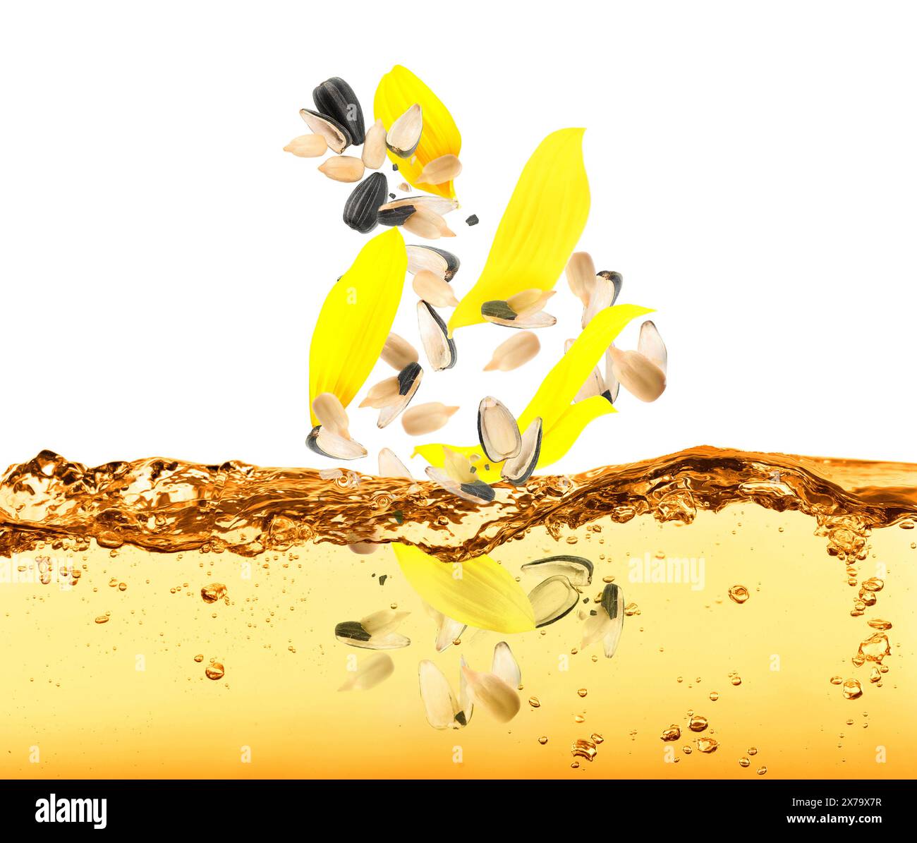 Sunflower seeds and petals falling into cooking oil on white background ...