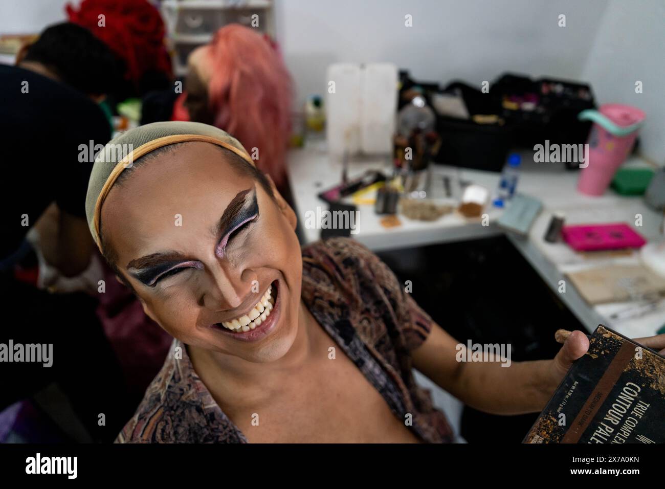 Thailand. 18th May, 2024. A drag queen smiles while doing their makeup ...