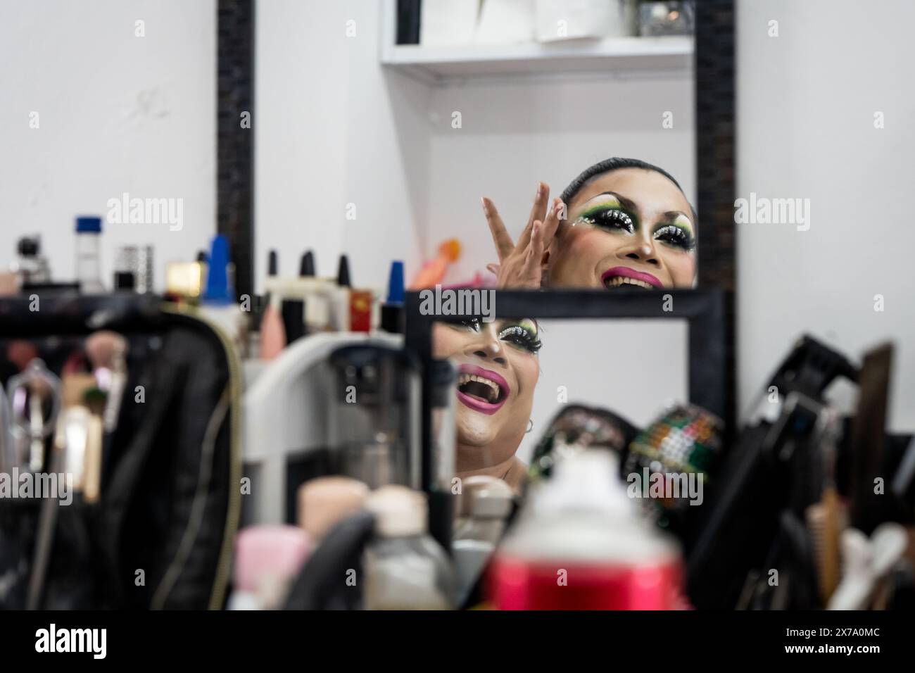 Srimala checks her makeup in the mirror backstage before the show. Drag ...