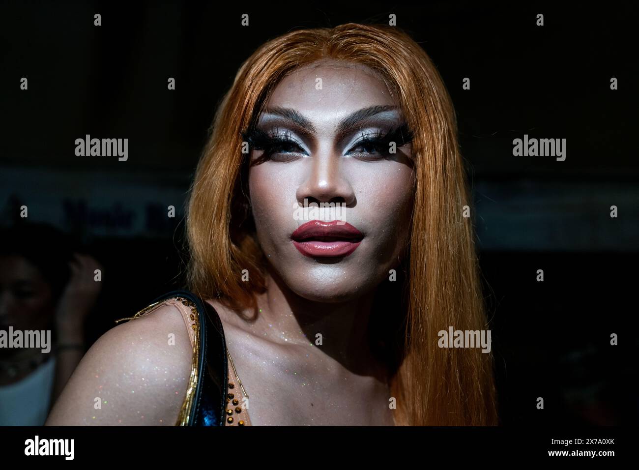 A Thai fan dressed in drag waits in line outside to meet Nymphia Wind ...
