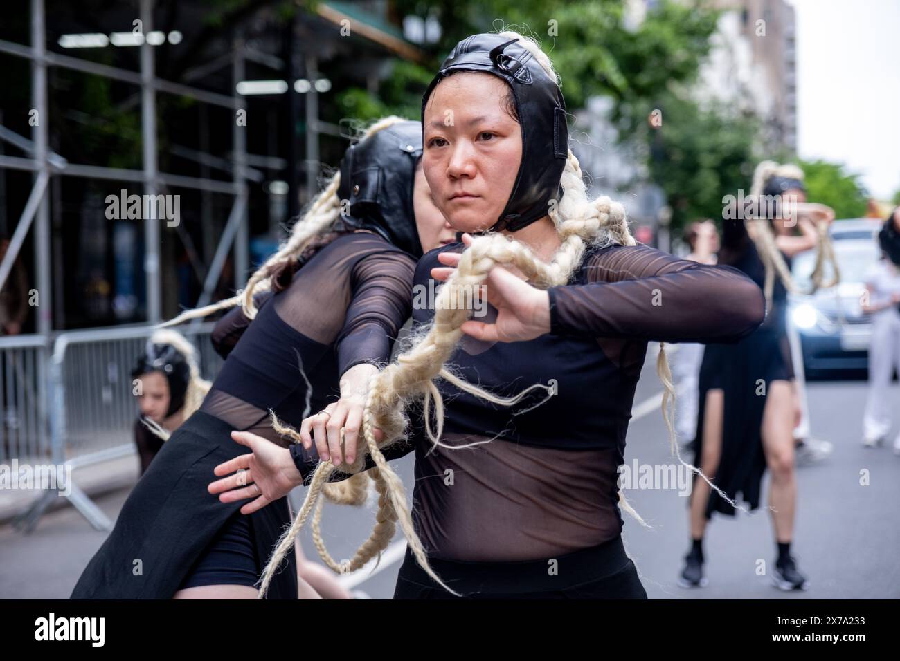 Dancers wearing head pieces with long blonde braids perform using hair ...