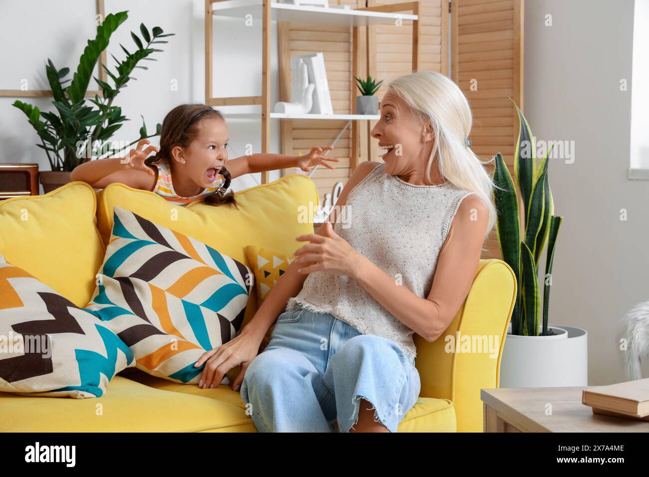 Little girl scaring her grandmother at home Stock Photo - Alamy