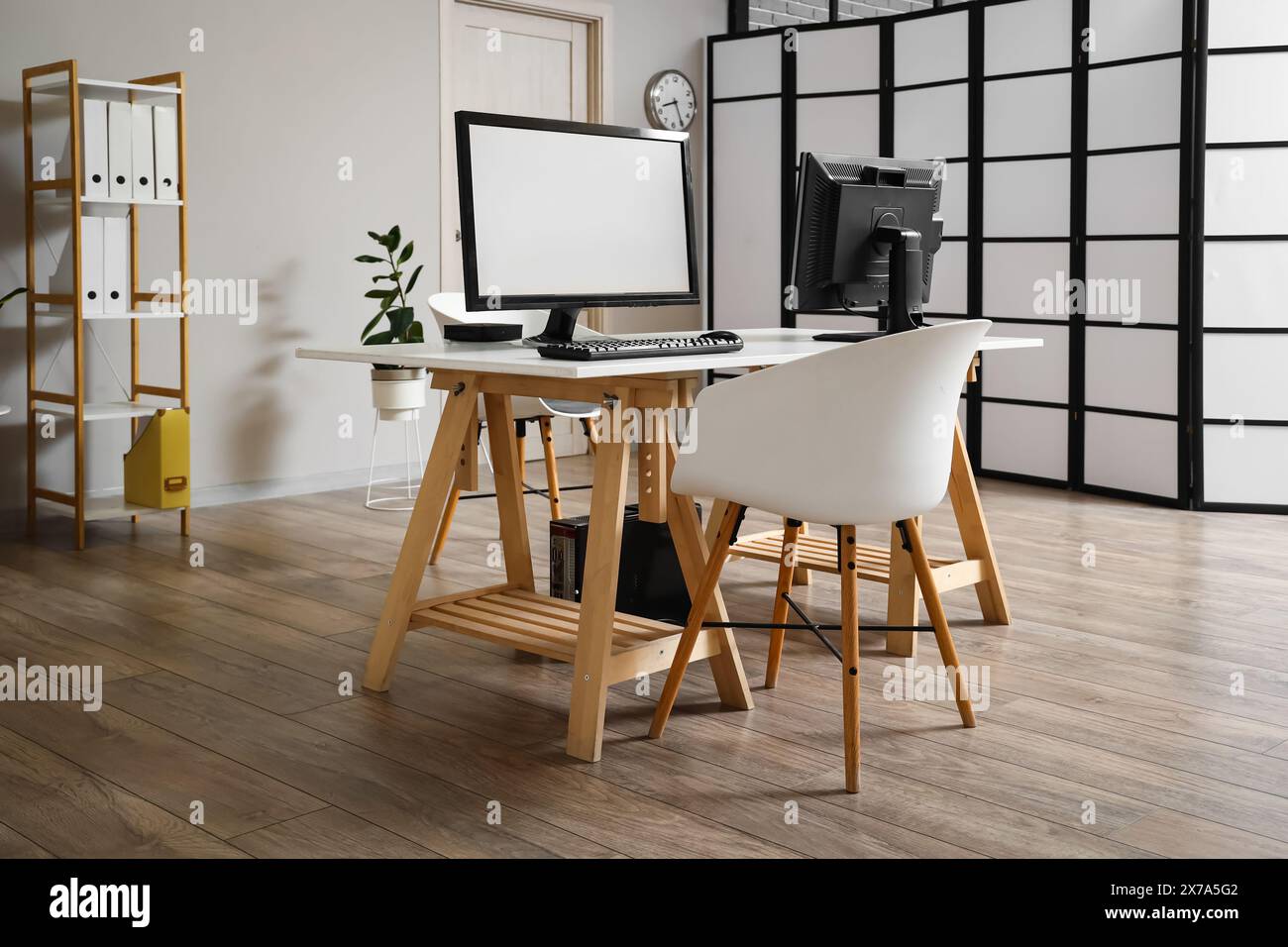 Modern desk with computer monitors in light office Stock Photo - Alamy