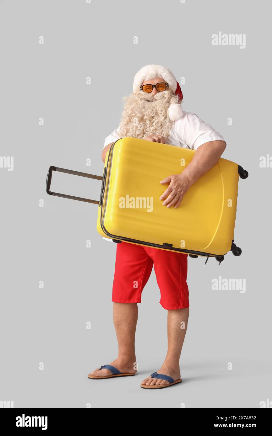 Santa Claus with suitcase on light background. Christmas in July Stock ...