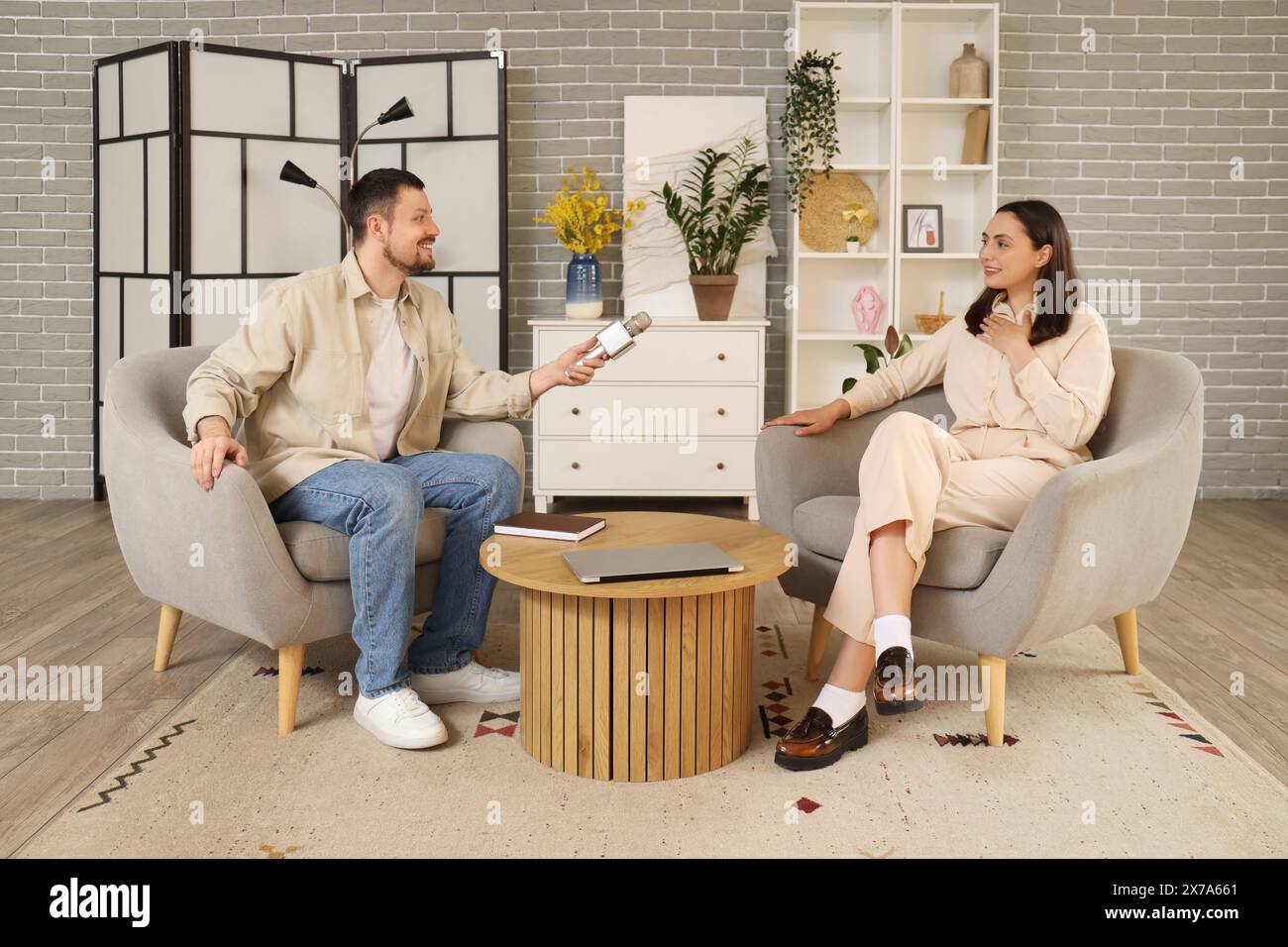Male reporter having interview with young woman in studio Stock Photo ...