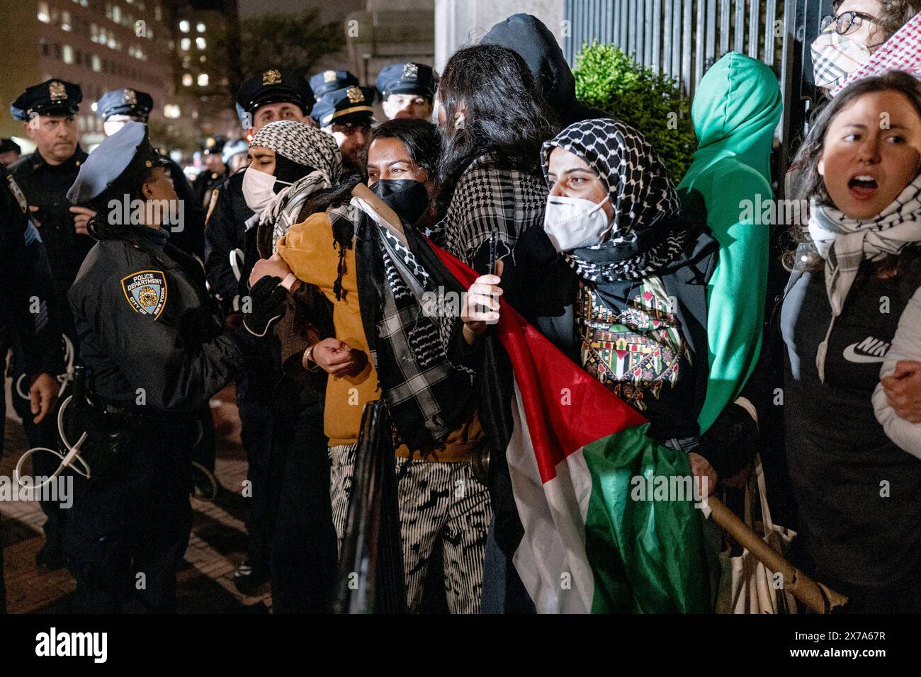 FILE - People hold their ground near a main gate at Columbia University ...