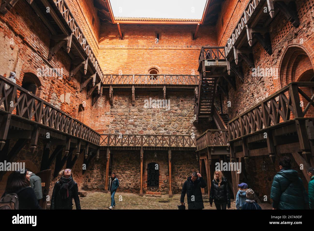 Visitors explore Trakai Island Castle, Lithuania. With its wooden ...