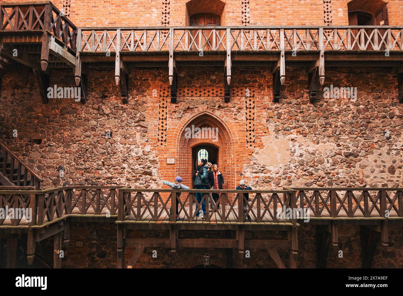 Visitors explore Trakai Island Castle, Lithuania. With its wooden ...