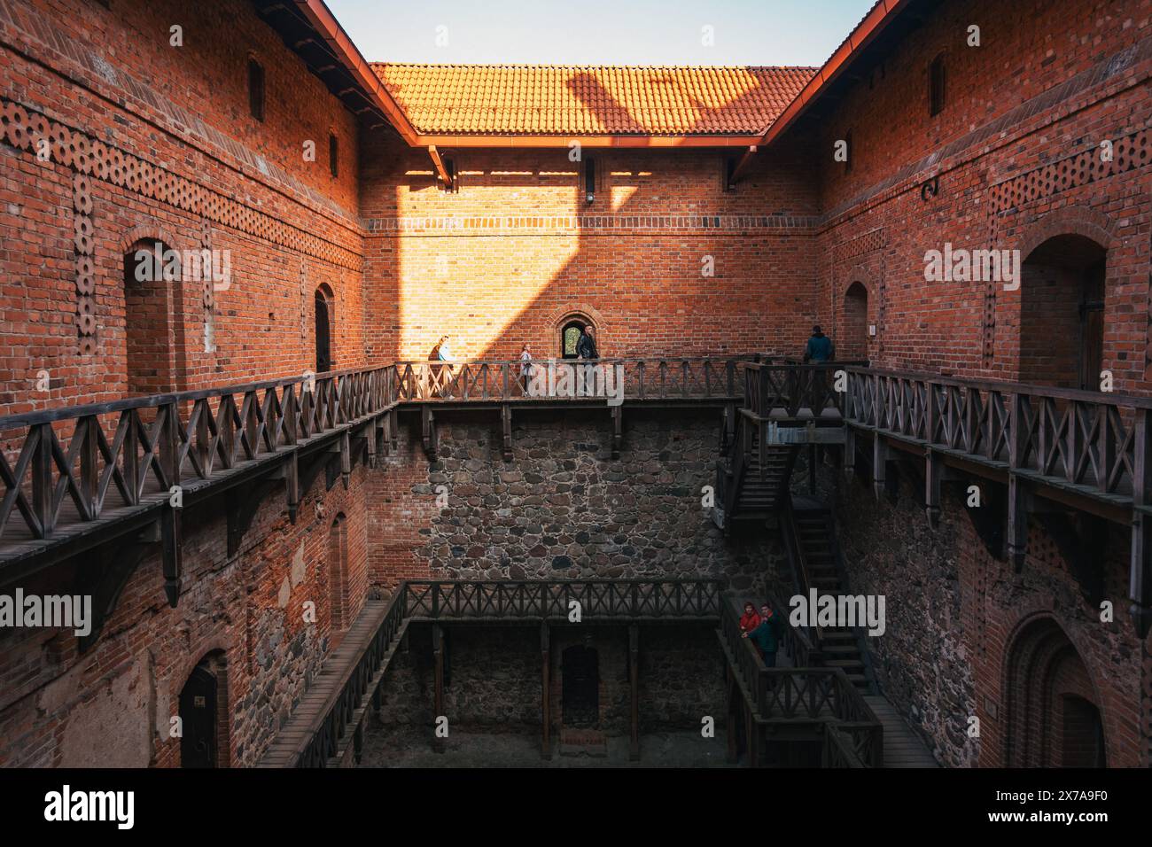 Visitors explore Trakai Island Castle, Lithuania. With its wooden ...