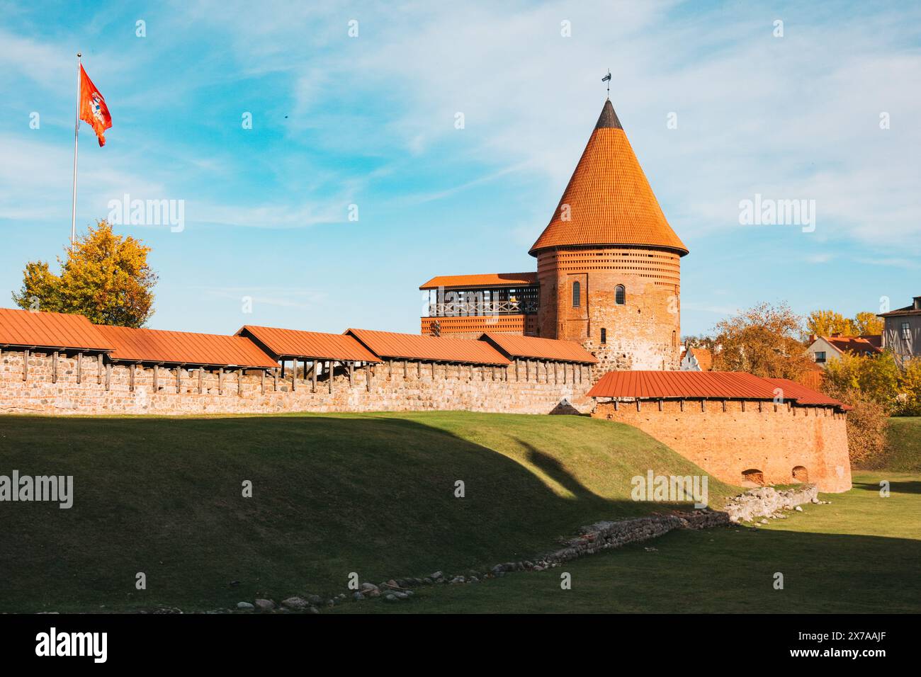 Kaunas Castle showcases its striking red towers, vibrant autumn foliage ...